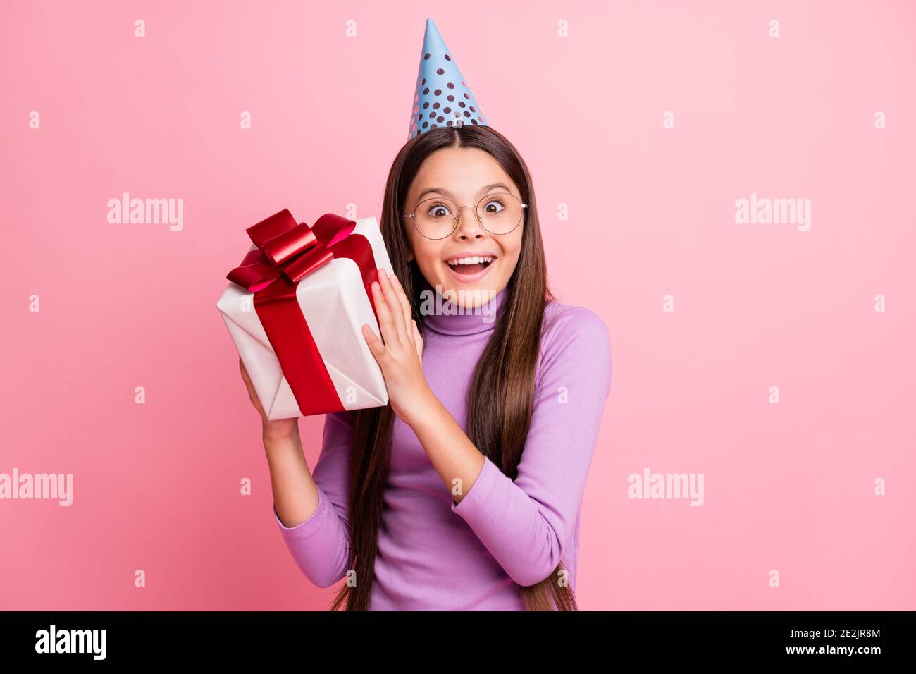 Photo of intrigued crazy little kid girl shake gift box wear violet ...