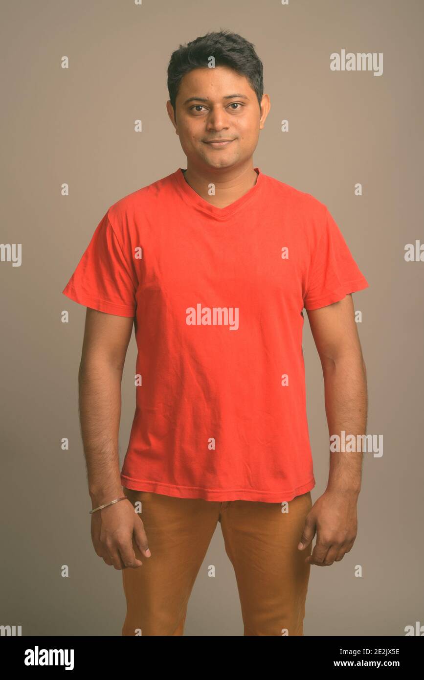 Young Indian man against gray background Stock Photo - Alamy