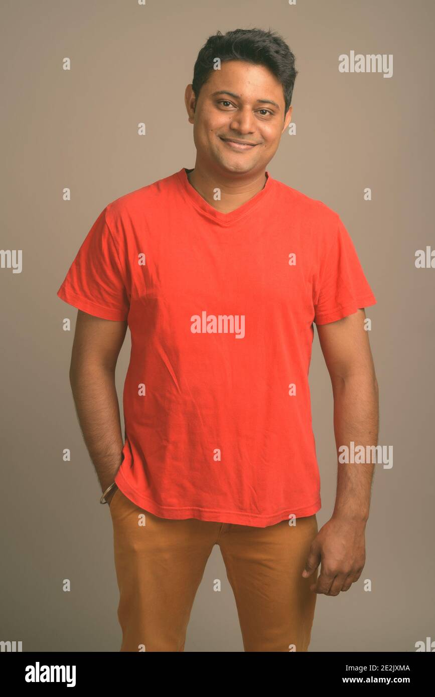 Young Indian man against gray background Stock Photo - Alamy