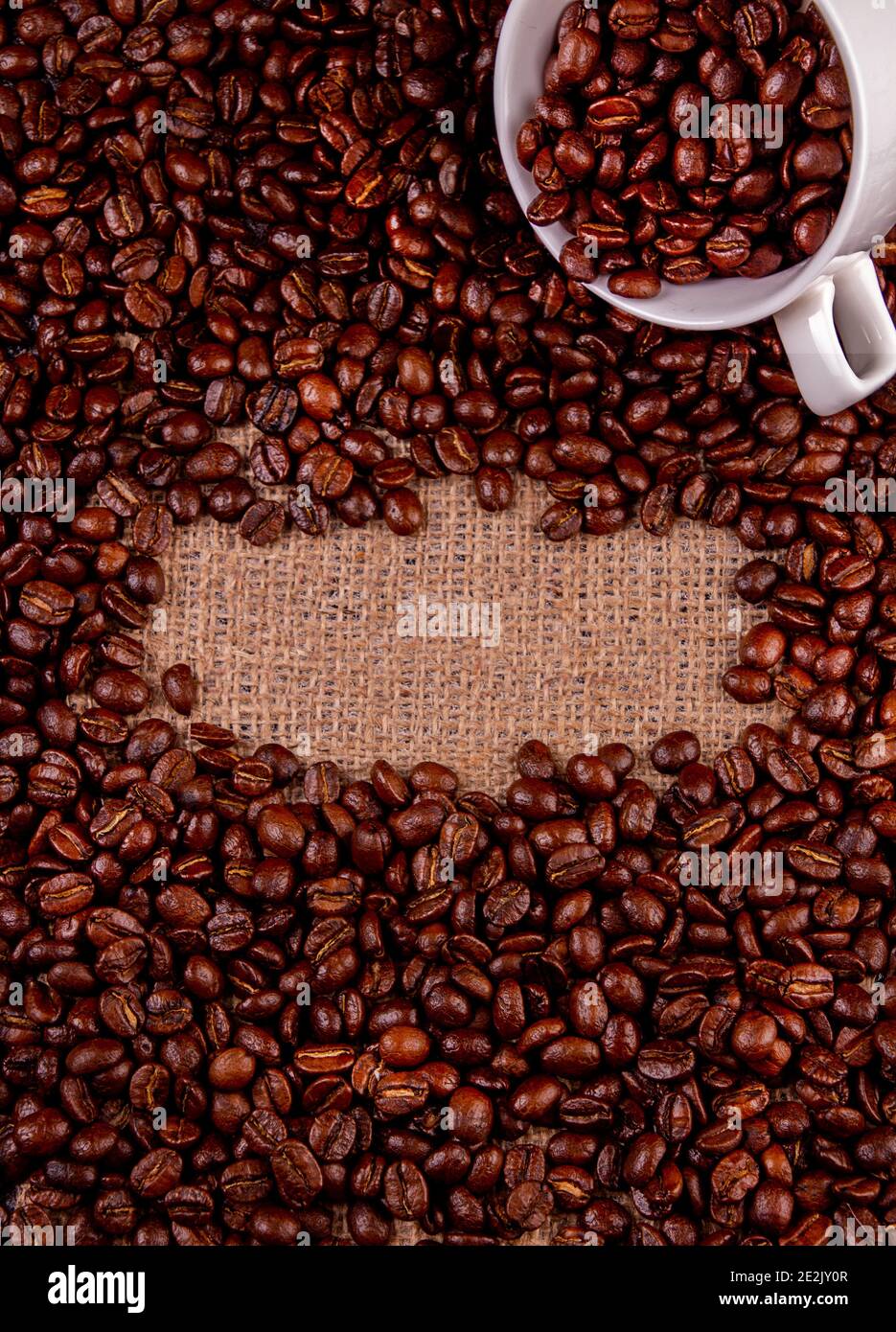 Roasted coffee grains background with place for text, cup with coffee ...