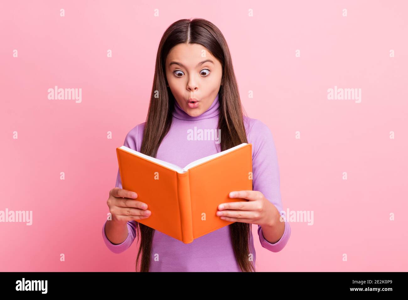 Photo of astonished latin kid girl read textbook wear purple jumper ...