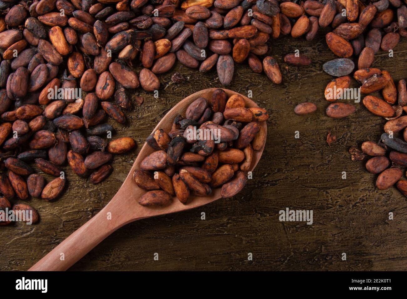 Texture of aromatic raw cocoa beans in wooden spoon top view Stock ...
