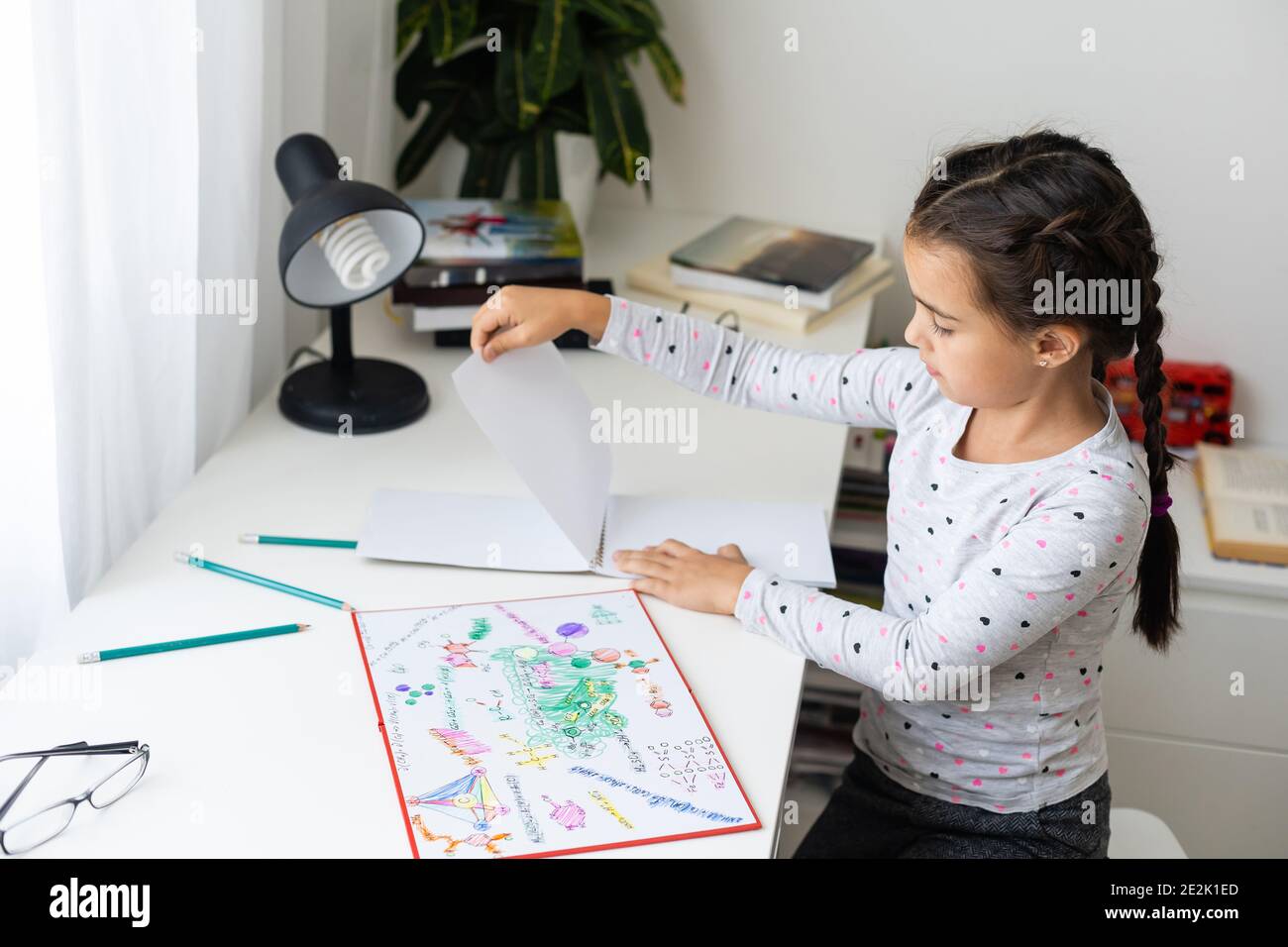 cute happy little girl writing something in her notebook Stock Photo ...