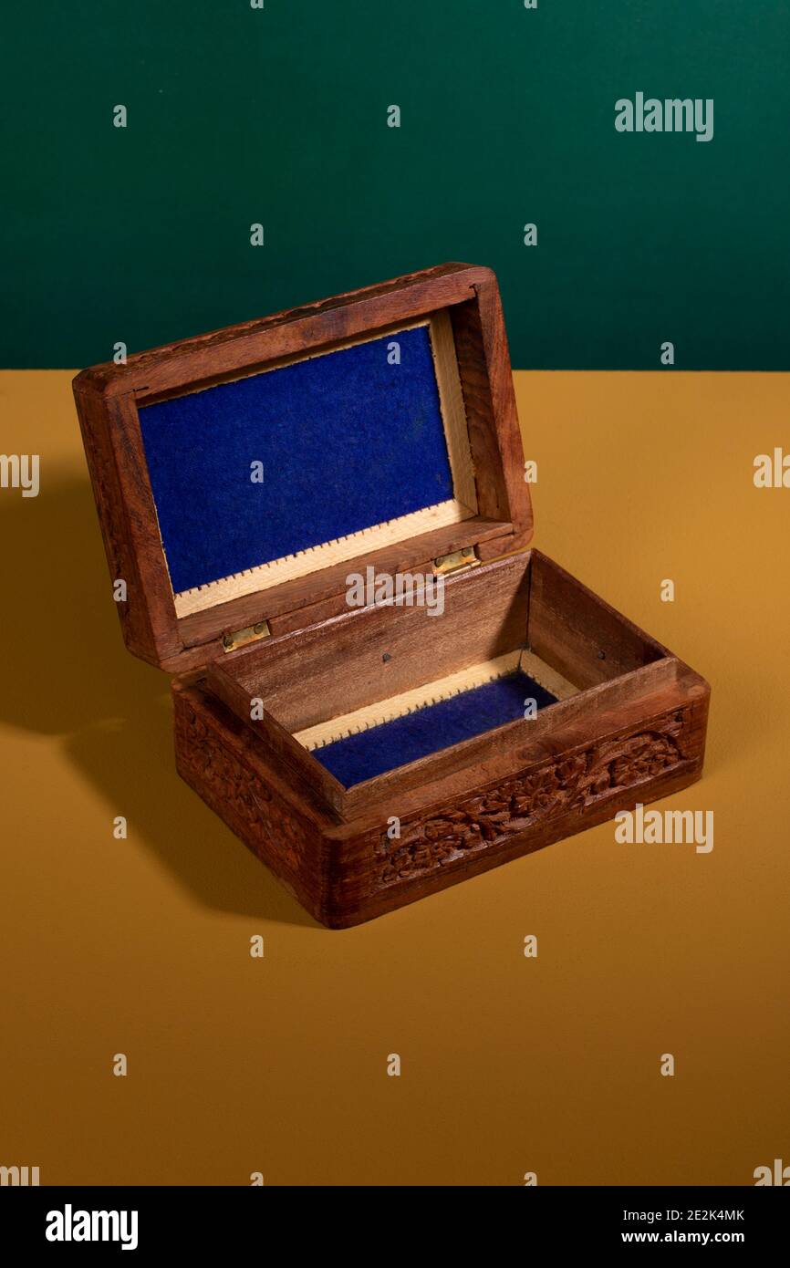 An old vintage handcarved wooden box in a dark brown color opened up on ...