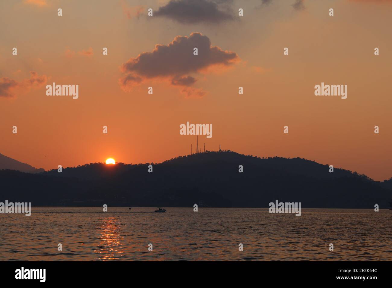 Sunset behind the hill. And the sea.Silhouette photo Stock Photo - Alamy