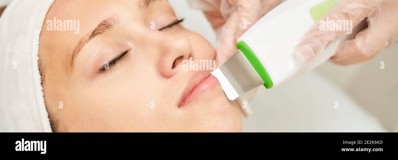 Ultrasonic skin equipment. Woman face cosmetology treatment. Female ...