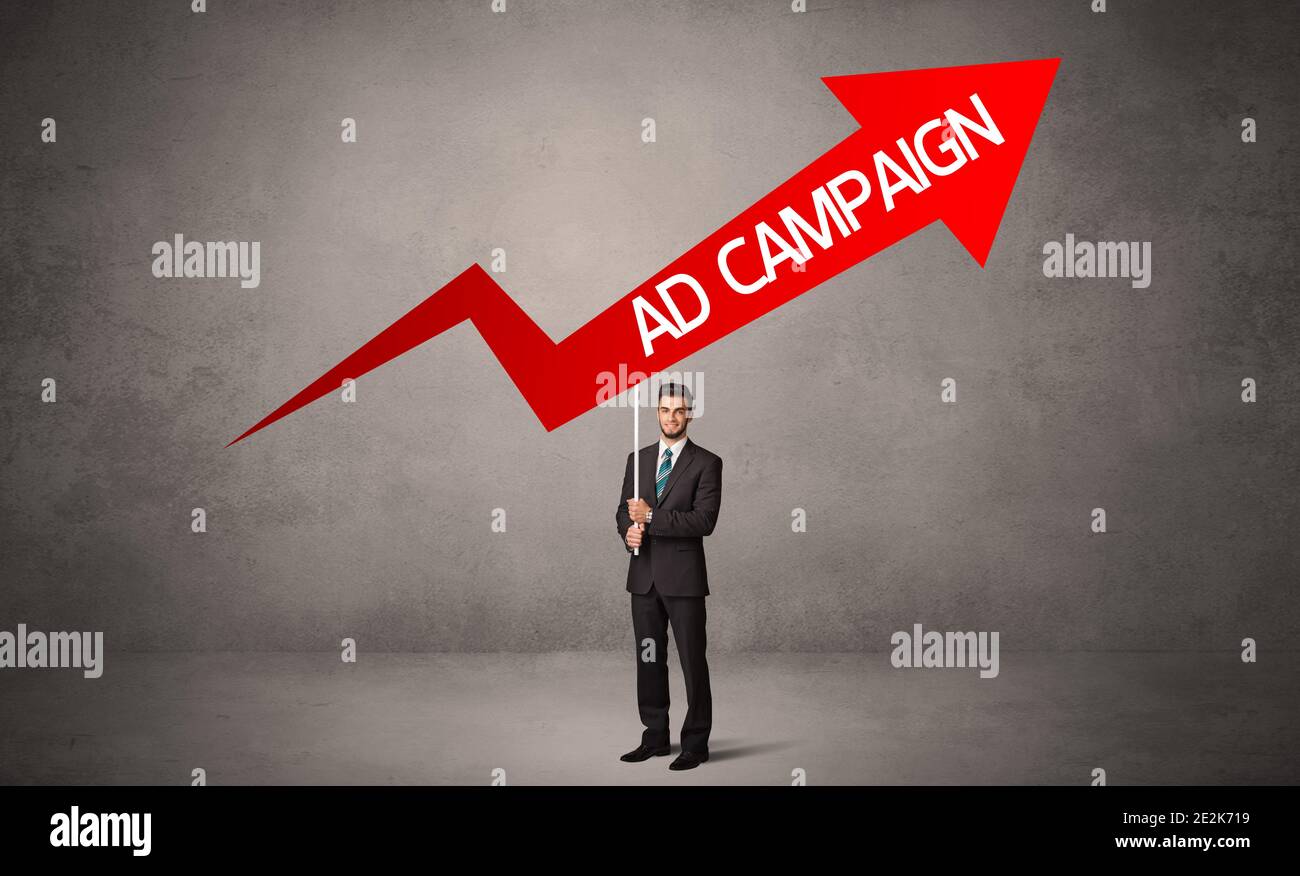 Young business person in casual holding road sign with AD CAMPAIGN ...