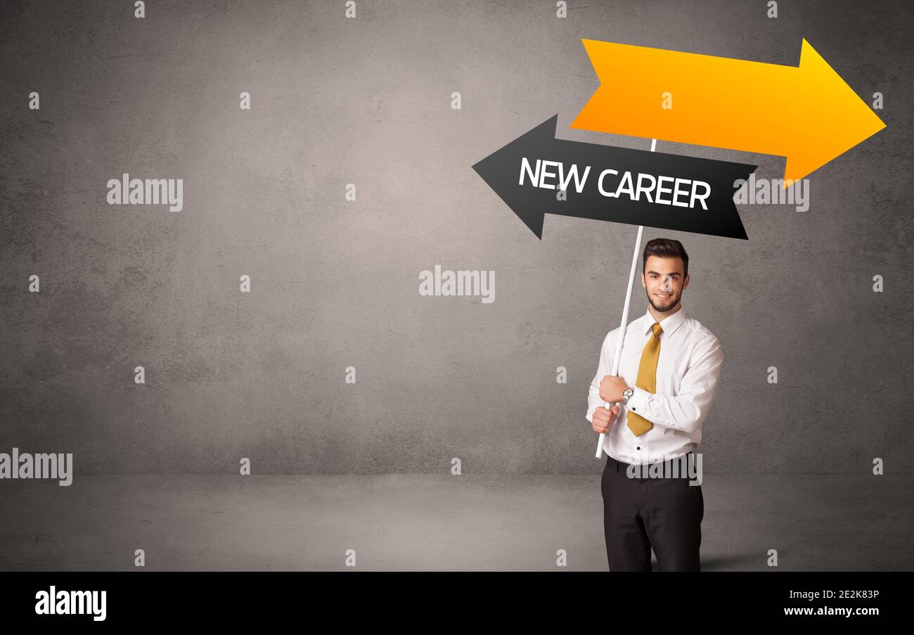 Young business person in casual holding road sign with NEW CAREER ...