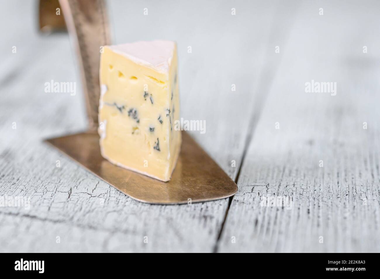 Wedge of blue cheese under a rind of white mould Stock Photo - Alamy