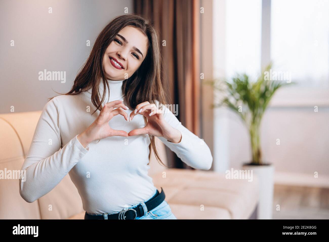 Lovely girl is giving love on photo at home. Cute female with nice ...