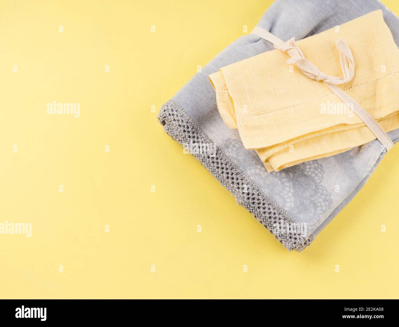 Folded yellow gray textile on yellow background Stock Photo - Alamy