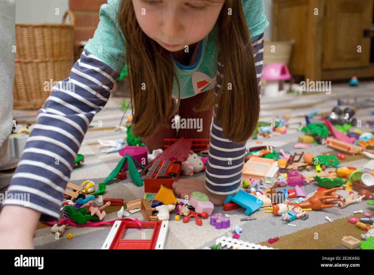 Young girl sat on floor playing with playmobil Stock Photo - Alamy