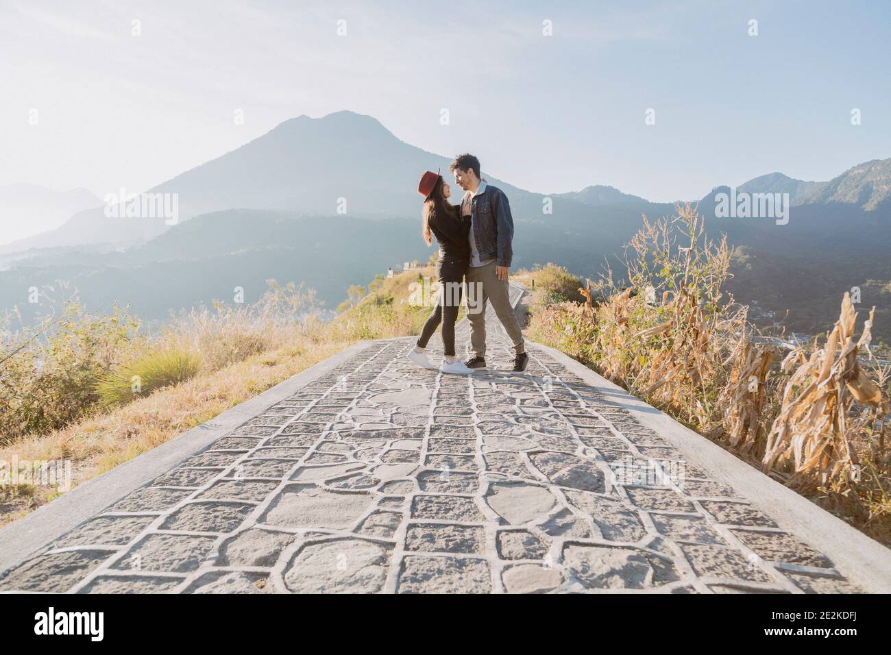 Traveler couple embracing in the middle of a mountaintop path at ...