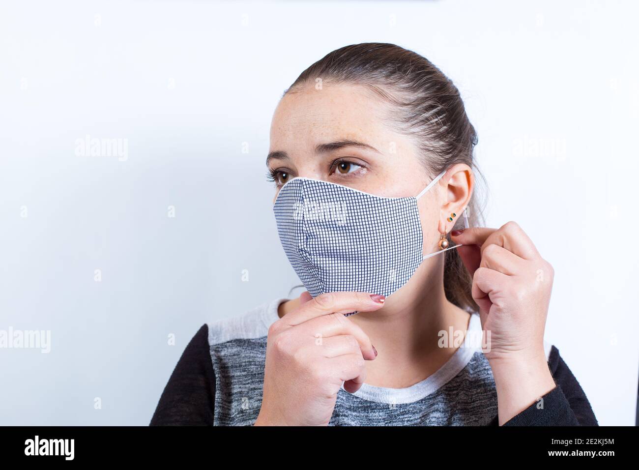 Young girl shows how to wear on mask on a white background Stock Photo ...