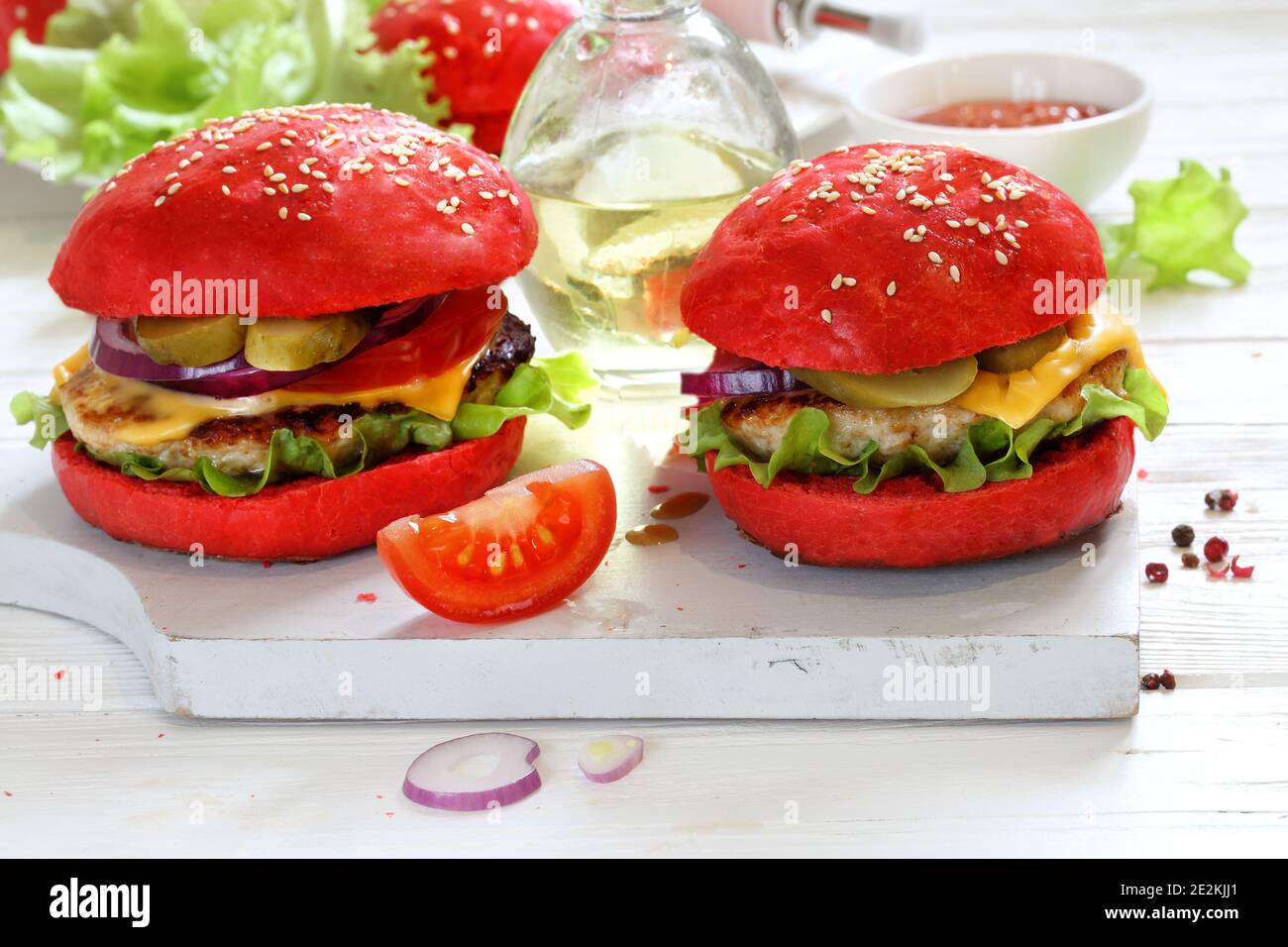 Burger with red bun and chicken cutlet on white plate Stock Photo - Alamy
