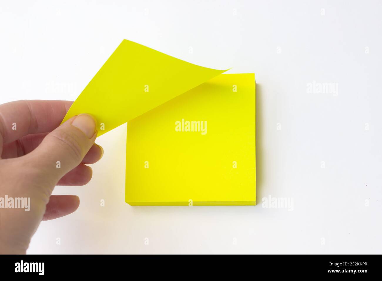 Hand pulls off yellow leaf post it. Blank yellow sticky note Stock ...