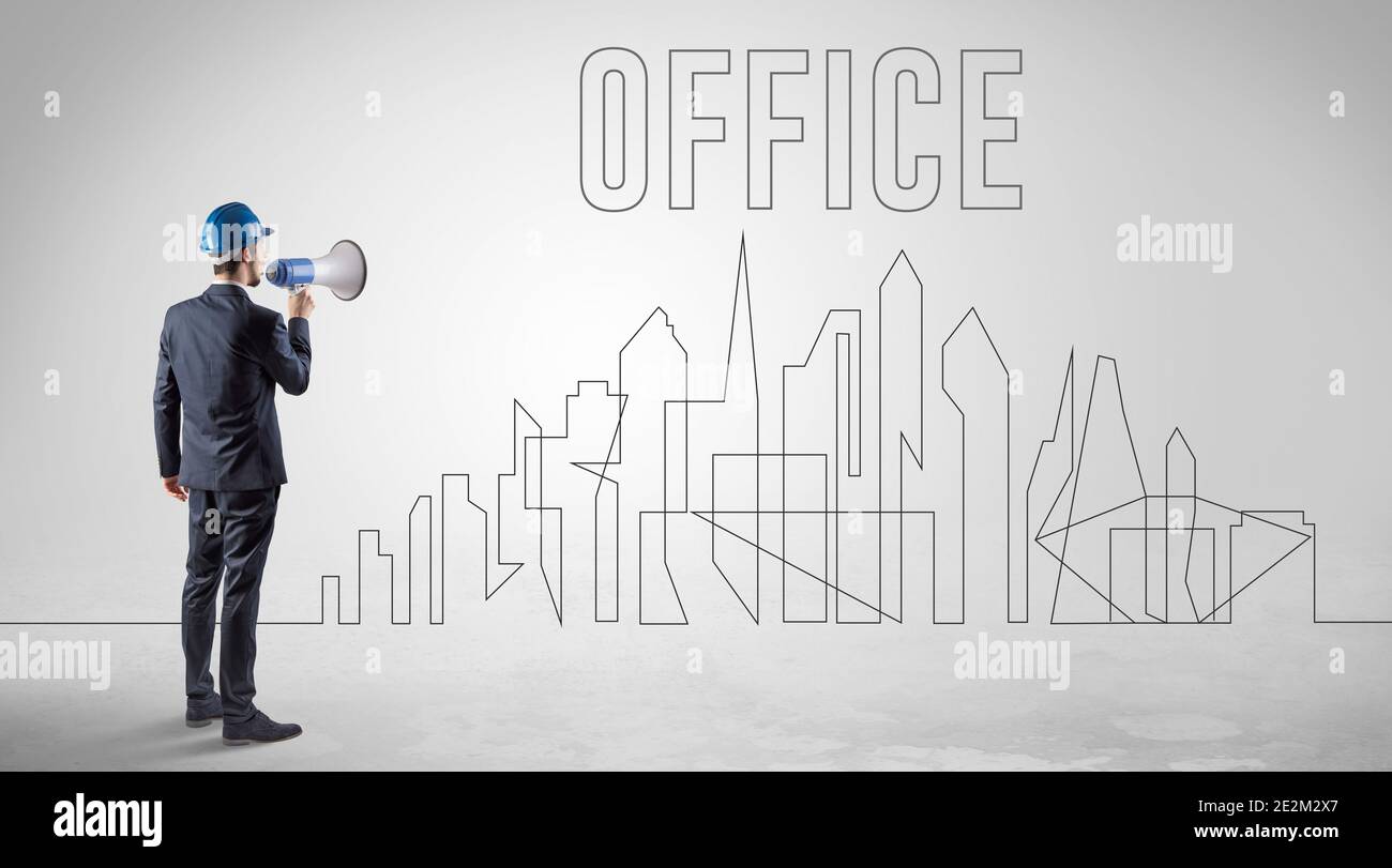 Businessman in hard hat holding blueprint with OFFICE inscription ...