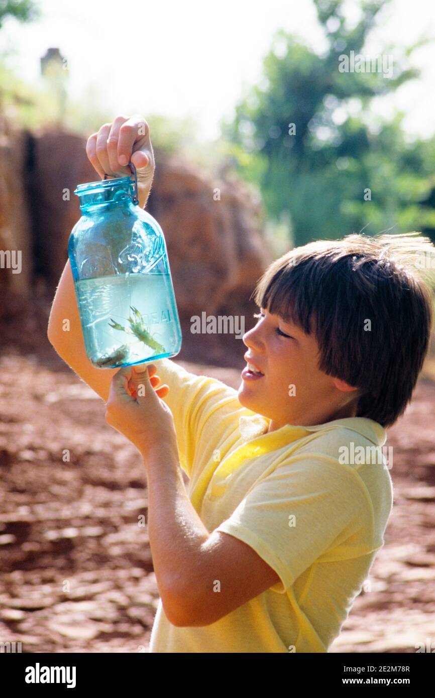 1980s BOY SCIENTIFICALLY INCLINED CURIOUS ABOUT NATURE HOLDING UP ...