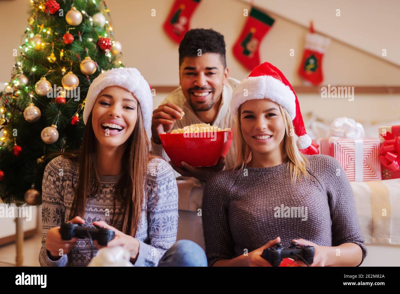 Two girlfriends playing video games while sitting on floor. Their ...