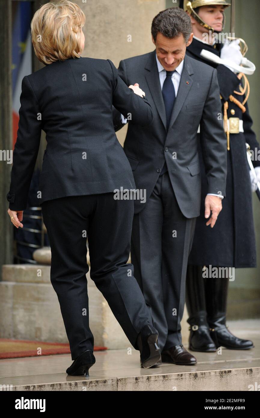 Secretary of State Hillary Clinton drops a shoe as she's greeted by ...