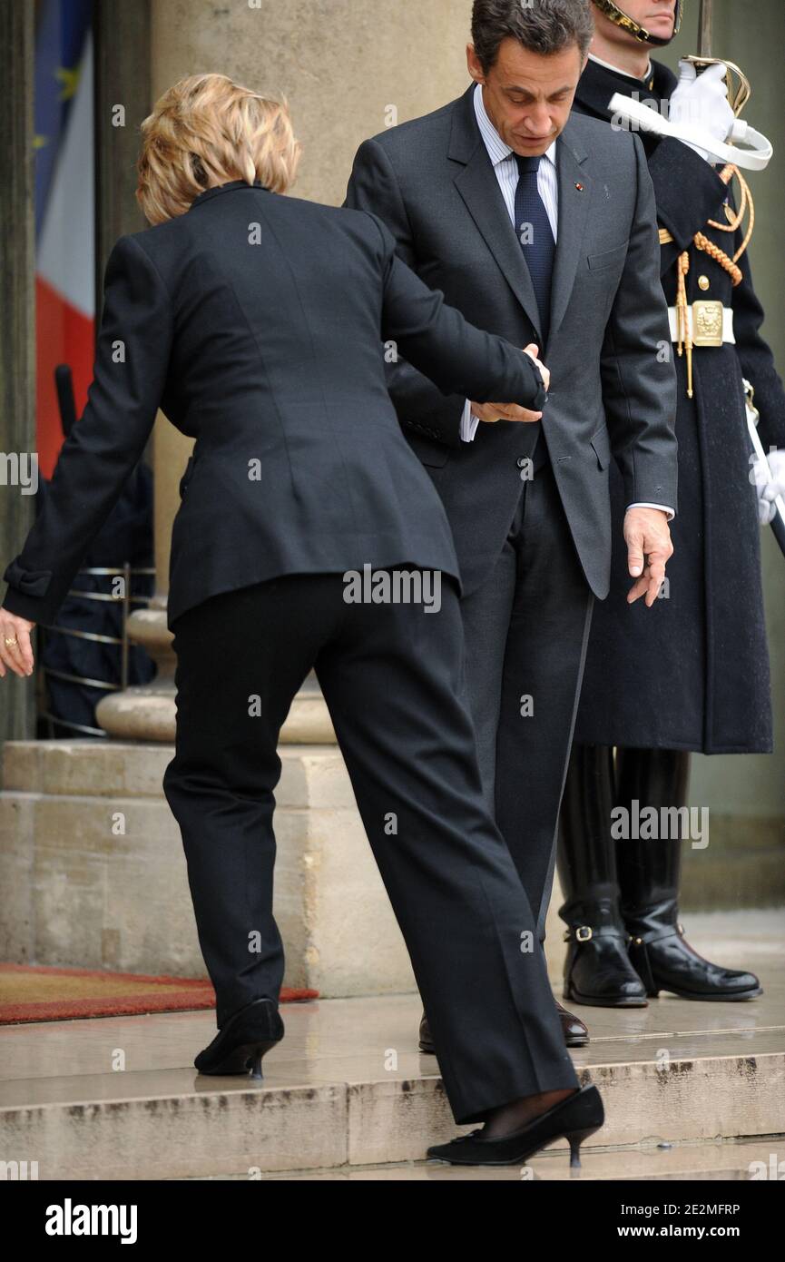 Secretary of State Hillary Clinton drops a shoe as she's greeted by ...