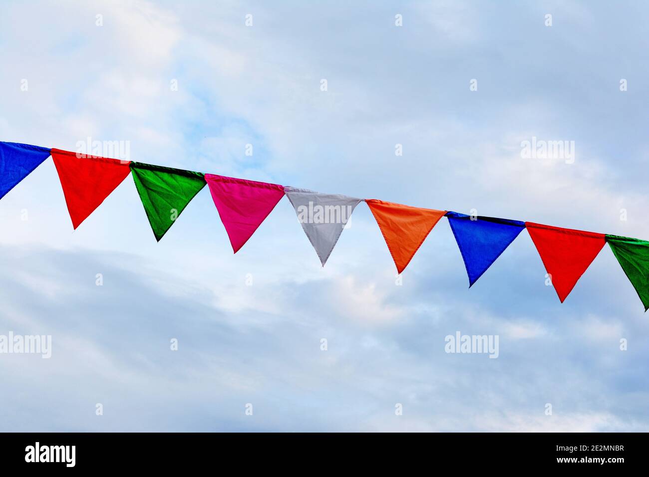 Colored triangular flags on blue sky background Stock Photo - Alamy