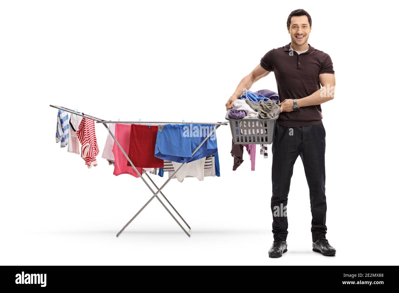 Full length portrait of a young man with a laundry basket and a line ...