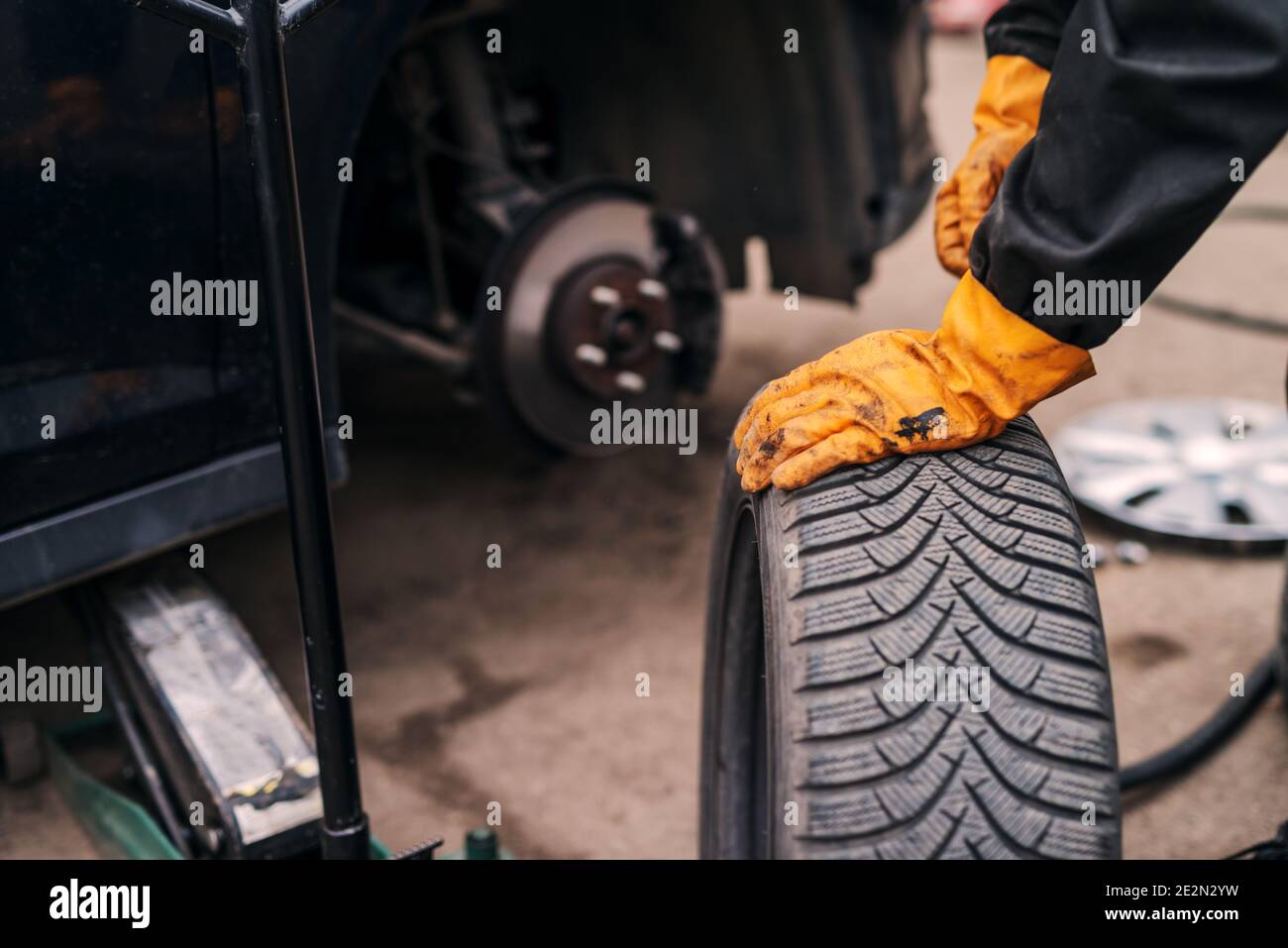 Picture of auto mechanics hands putting car tire on cr in workshop ...