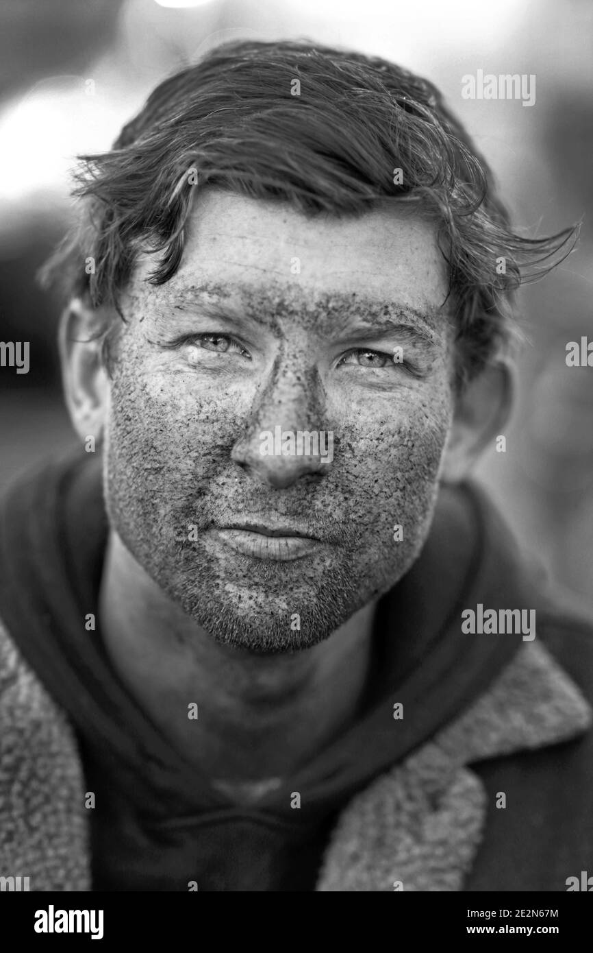 Close up of man covered by mud.A man's face covered in muddy spots ...