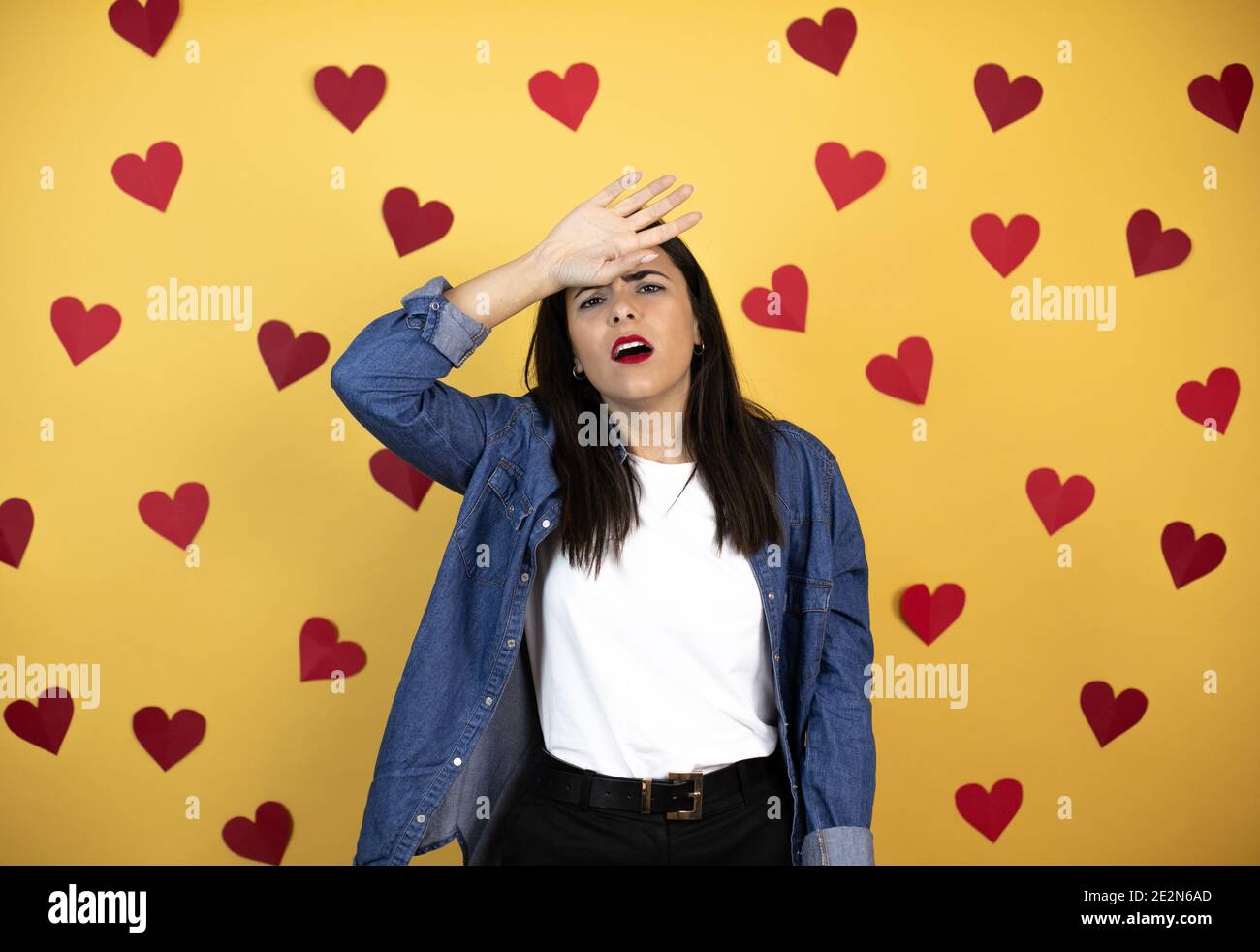 Young caucasian woman over yellow background with red hearts Touching ...