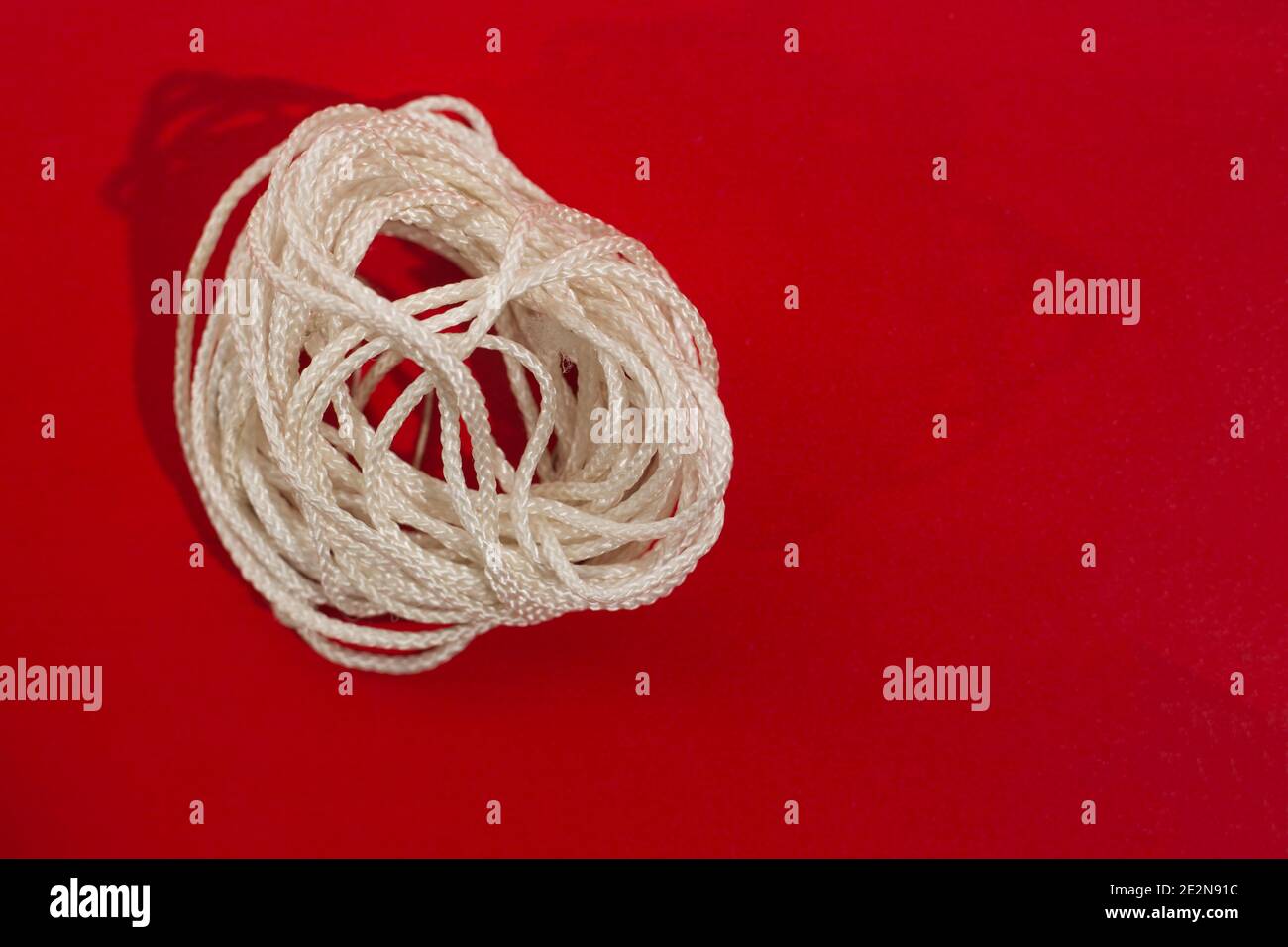 Top view of white string on a red surface Stock Photo - Alamy