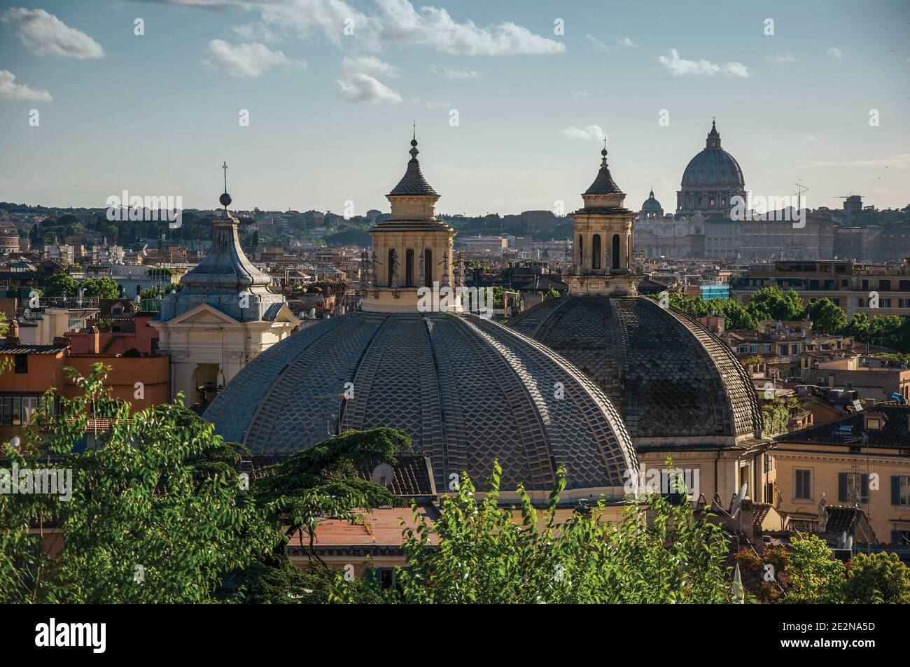 Overview of trees, cathedrals domes and roofs of buildings in Rome. The ...