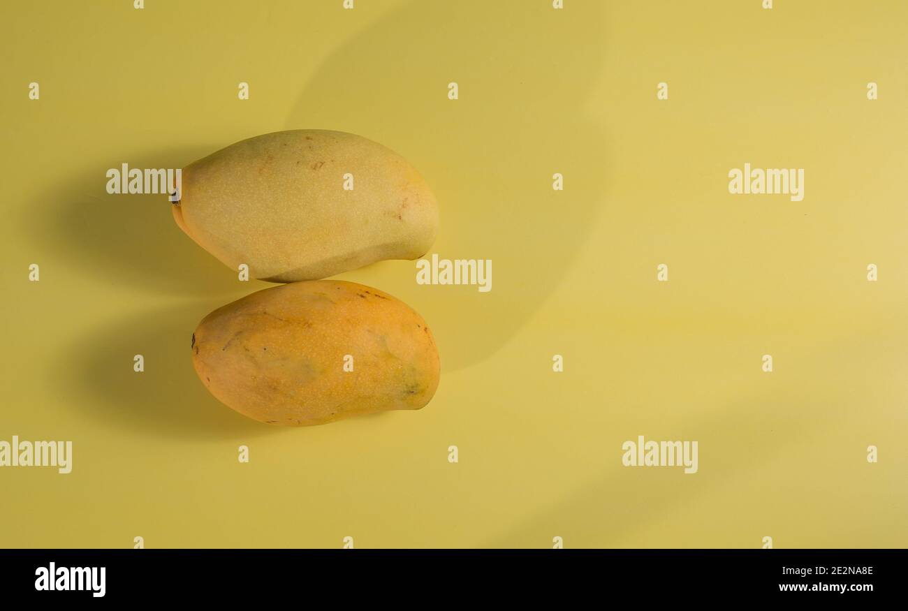Top view of yellow mangoes on a yellow surface Stock Photo - Alamy