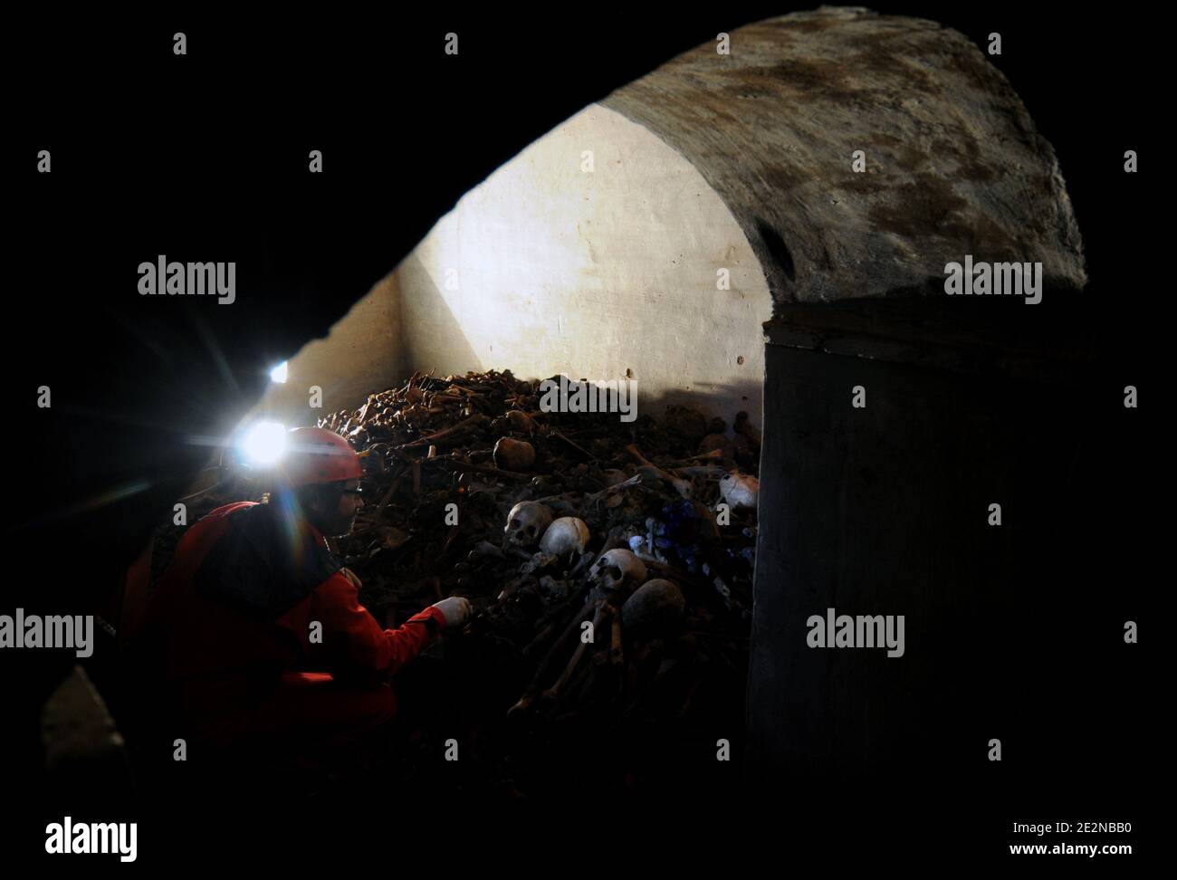 italian speleologist Antonio Moretti looks at skulls inside a crypt in ...