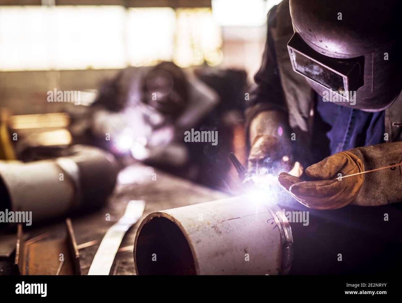 Close up of a male fabric worker cutting metal pipe with an electric ...