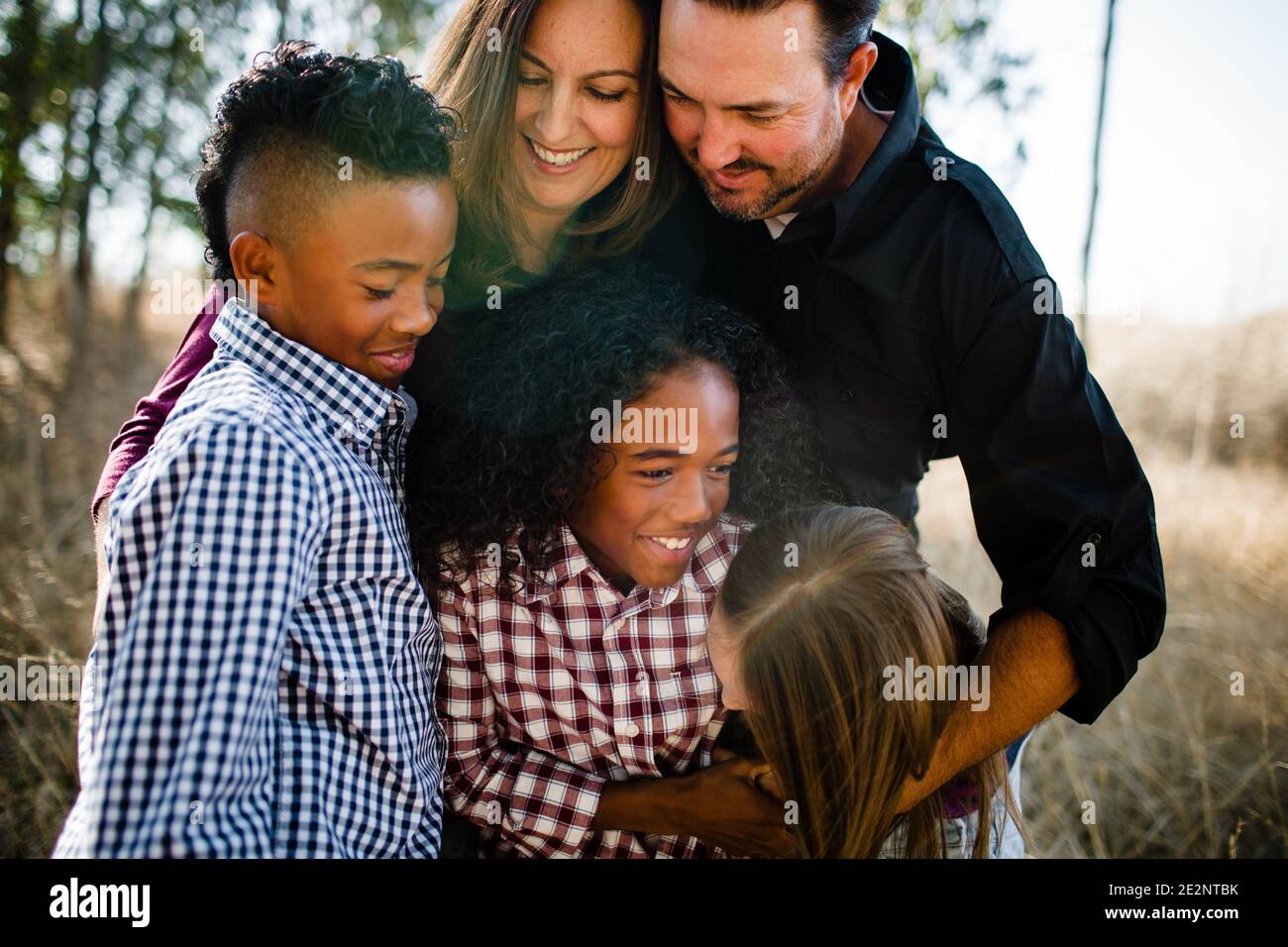 Family of Five Standing in Field Smiling & Hugging Stock Photo - Alamy