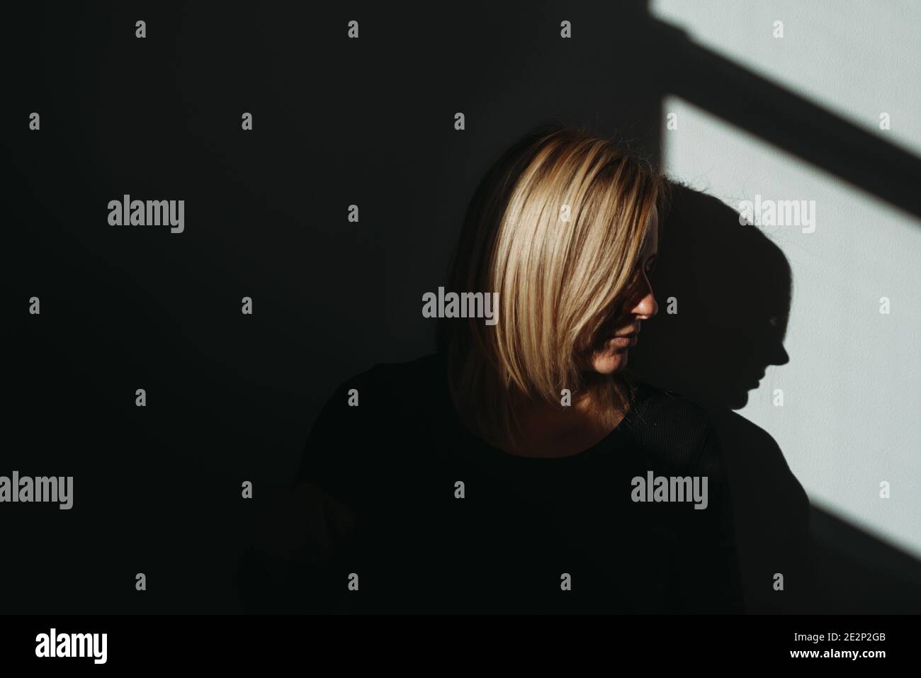 Woman's profile in bright light with black background and shadows Stock ...