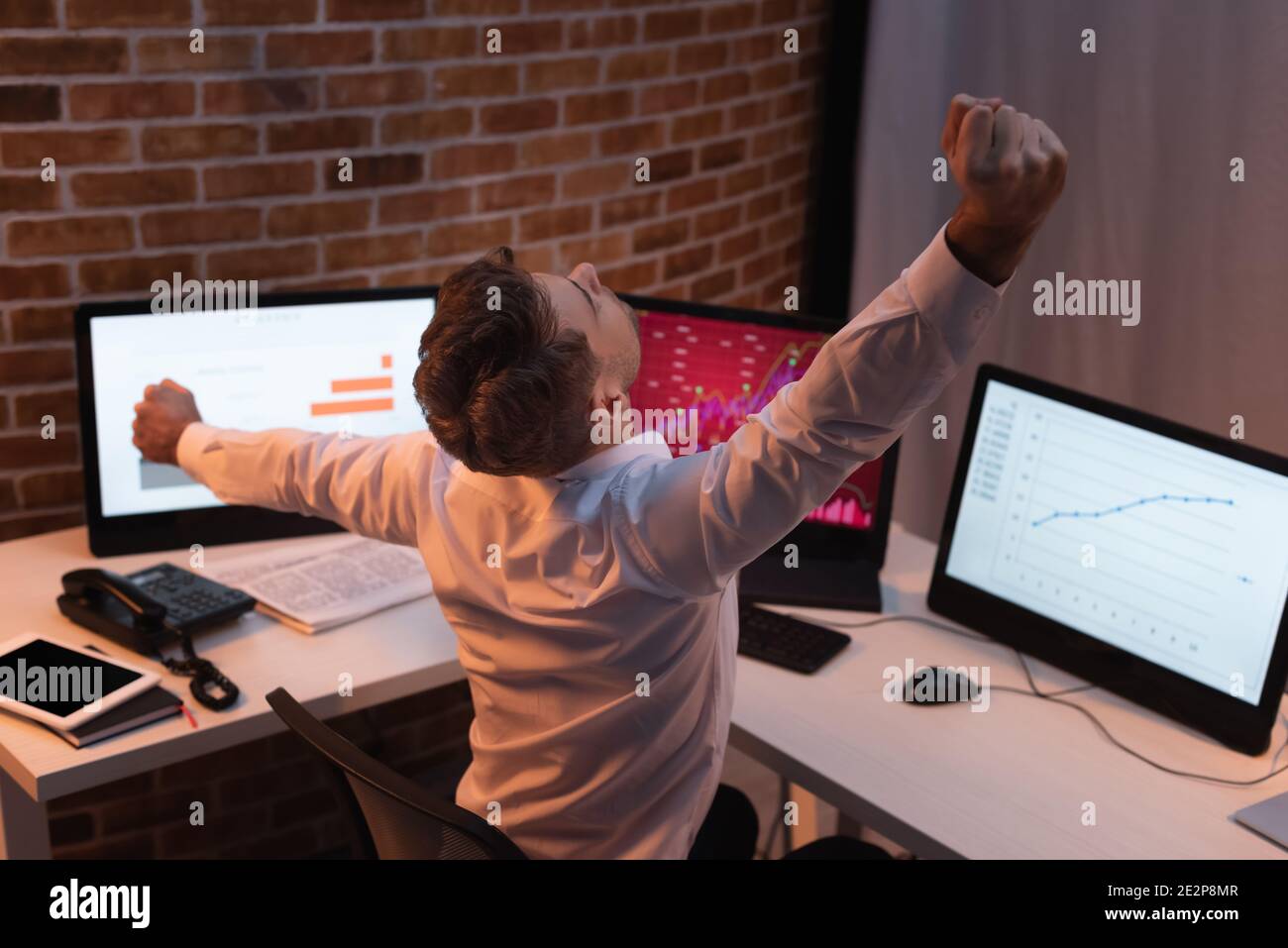 Businessman stretching near computers with charts on blurred background ...