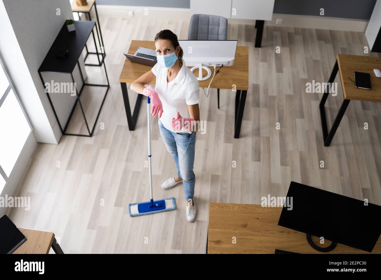 Female Janitor Mopping Floor In Face Mask In Office Stock Photo - Alamy