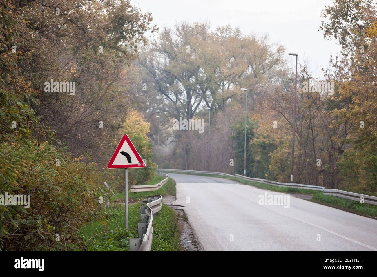 European curve roadsign on a forest asphalted road with its typical ...