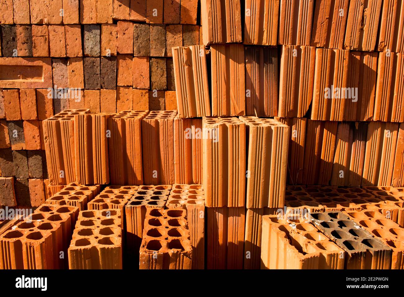 Frontal view of stacks of red and brown clay bricks and blocks for ...
