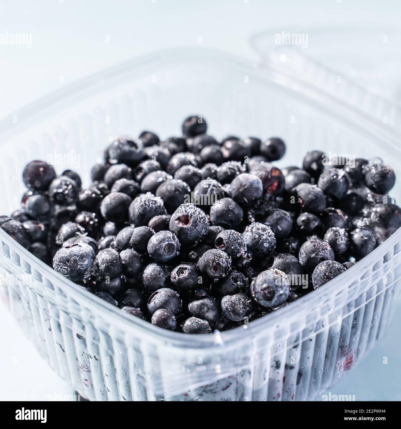 Close up on fresh blueberries in plastic box frozen and ready to eat ...