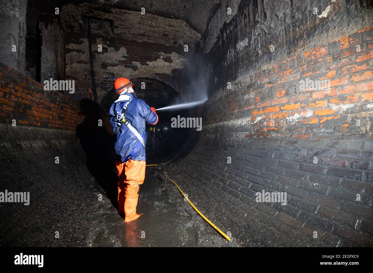 Hamburg, Germany. 14th Jan, 2021. A sewer worker uses a water hose to ...