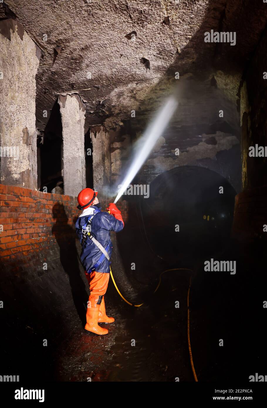 Hamburg, Germany. 14th Jan, 2021. A sewer worker uses a water hose to ...