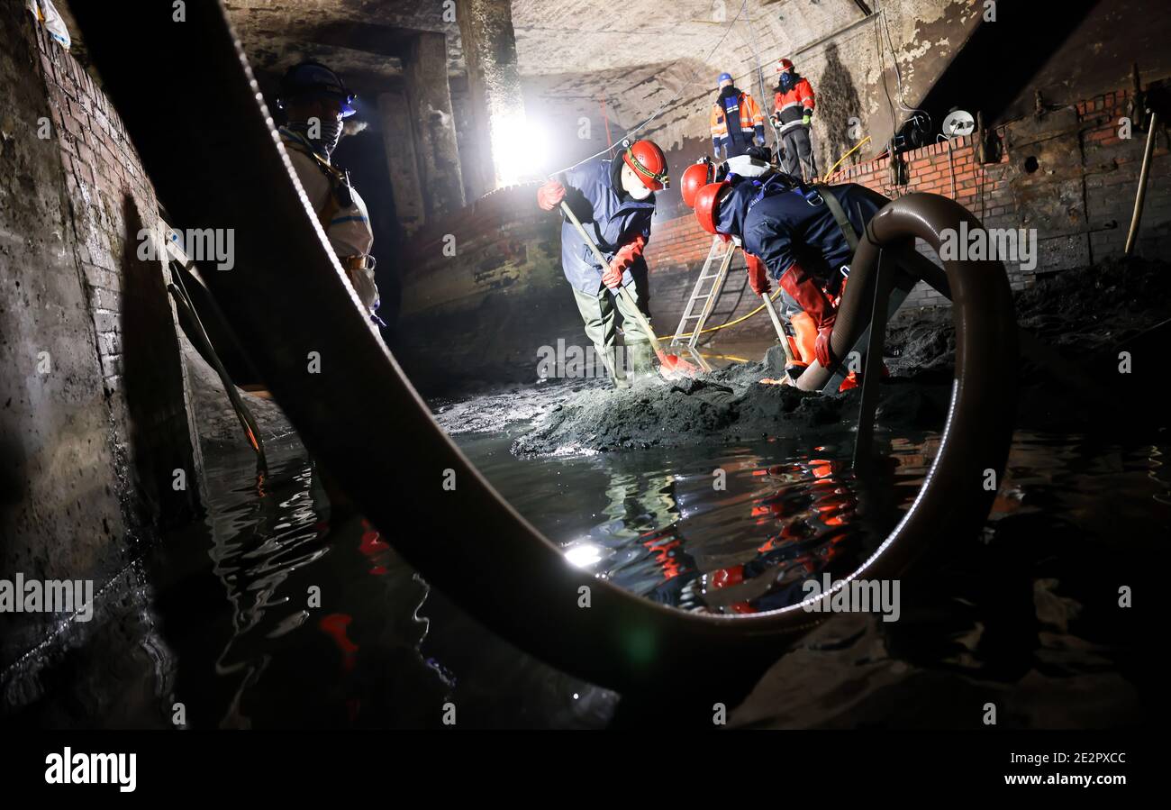 Hamburg, Germany. 14th Jan, 2021. Sewer workers use shovels and suction ...
