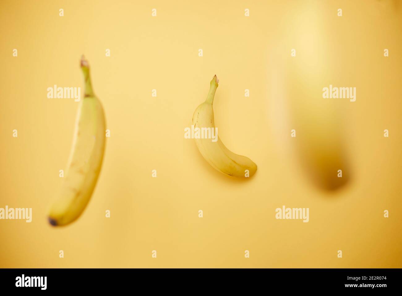 Flying bananas in Front of a Yellow background Stock Photo - Alamy