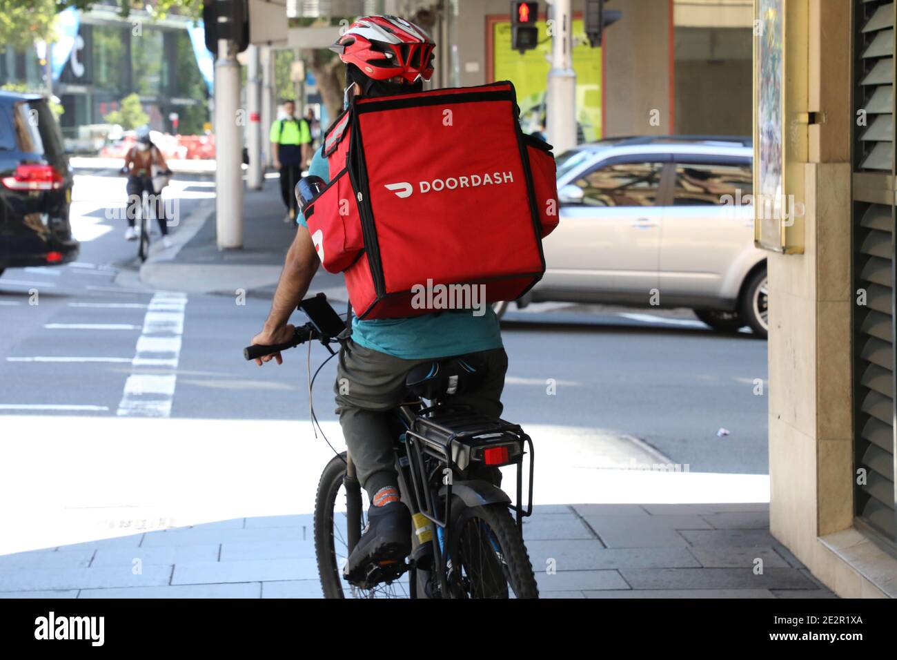 A DoorDash food delivery rider rides his bicycle illegally on the ...