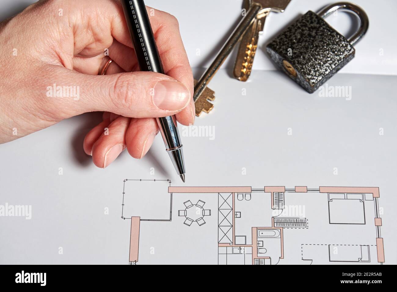 Man hand with a pen, flat layout draft, lock and keys. Real estate sale ...