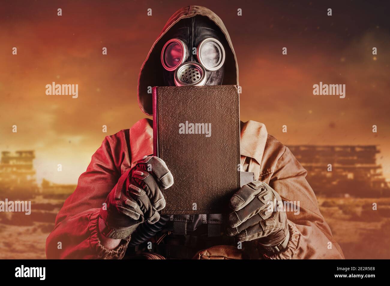 Photo of stalker soldier in soviet gas mask holding closed old book on ...