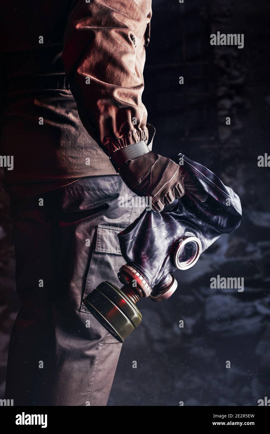 Photo of stalker hand in jacket and gloves holding old solviet rubber ...